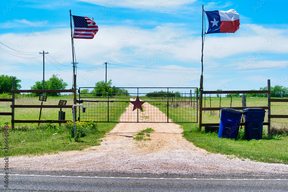 American and Texas state flags flying near countryside gate, Texas ...