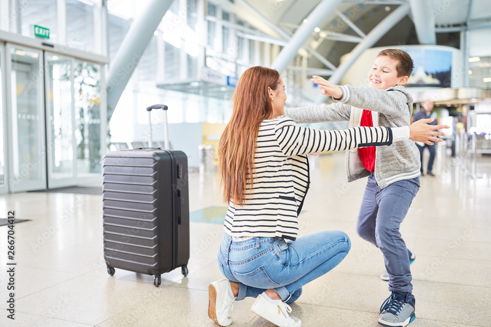 Stockfoto Sohn begrüßt seine Mutter im Flughafen Terminal | Adobe Stock