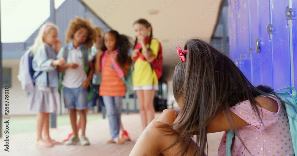 Schoolkids bullying a crying Asian girl in the corridor of elementary ...