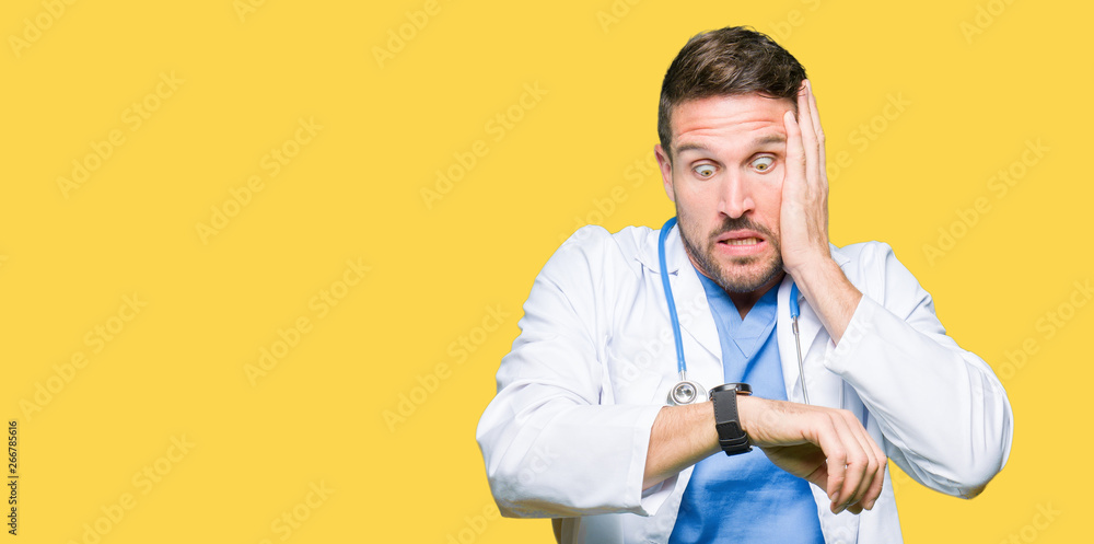 Handsome doctor man wearing medical uniform over isolated background ...