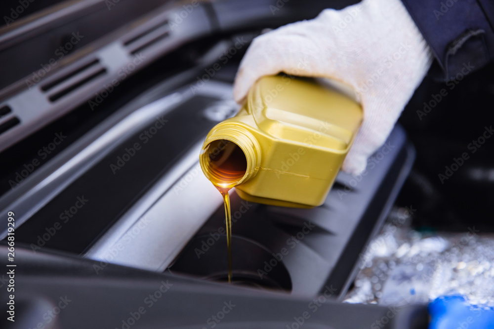 Topping up the engine oil plastic capacity in the car engine with a ...