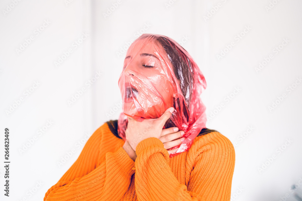 Young woman with plastic bag on her head choking, antipollution save ...