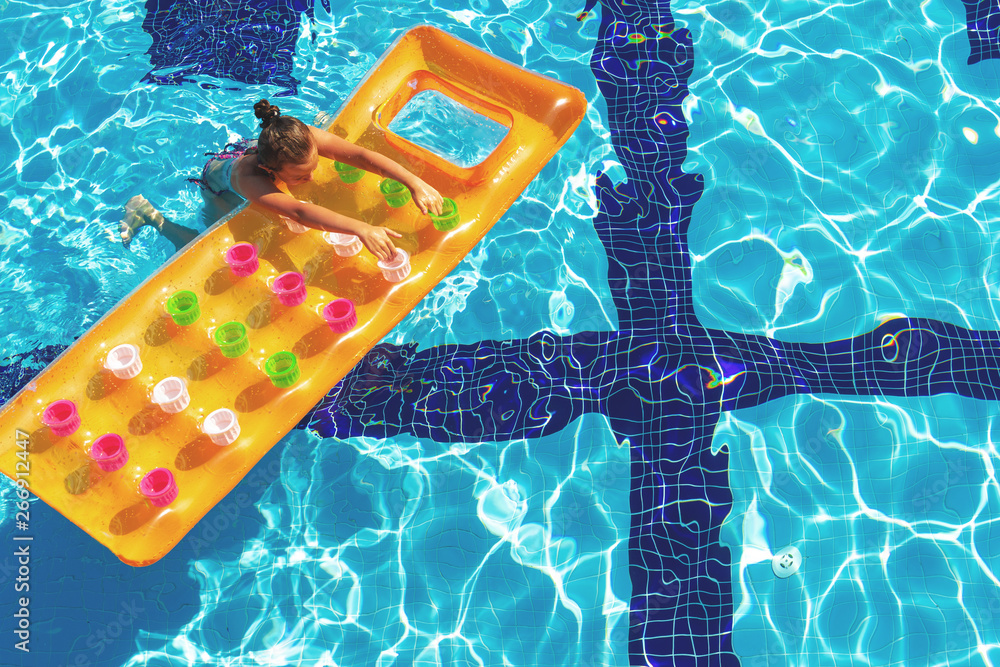 Little girl on a floating orange air mattress in the pool Stock Photo ...