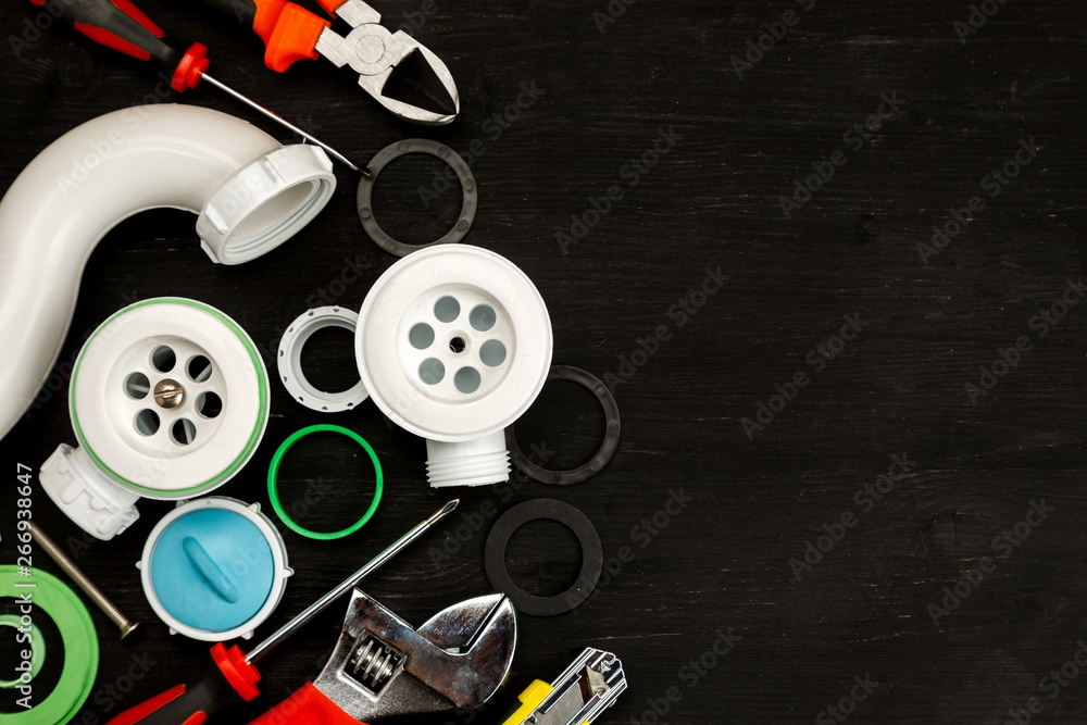 Parts of sink drain kit with tools on a black background, text space ...