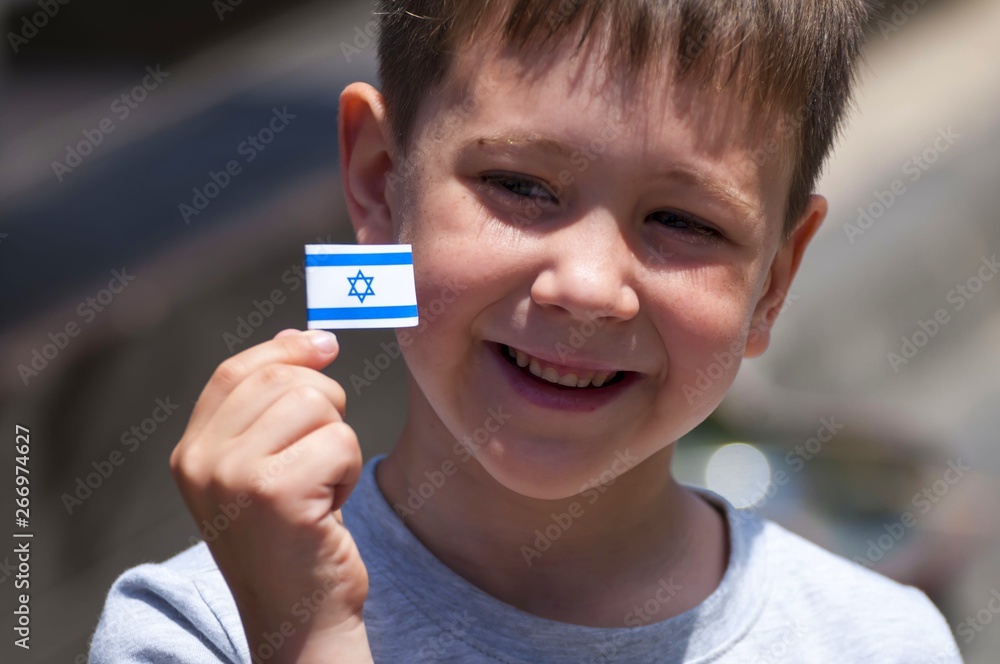 Happy Israeli Caucasian Jewish child with a tiny flag of Israel in his ...