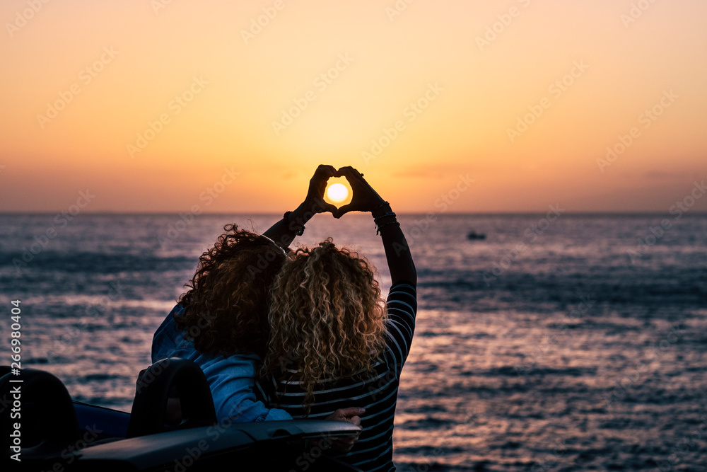 Romantic friendship people concept with two curly lady viewed from back ...