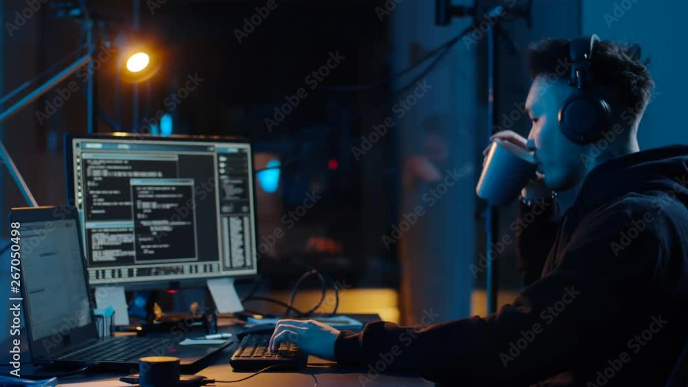 cybercrime, hacking and technology concept - asian male hacker in ...