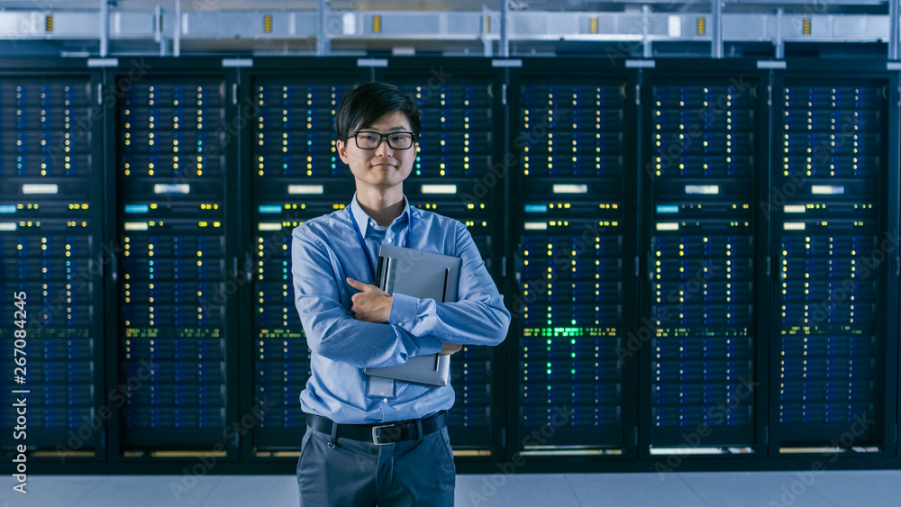 In the Modern Data Center: Portrait of IT Engineer Standing with Server ...