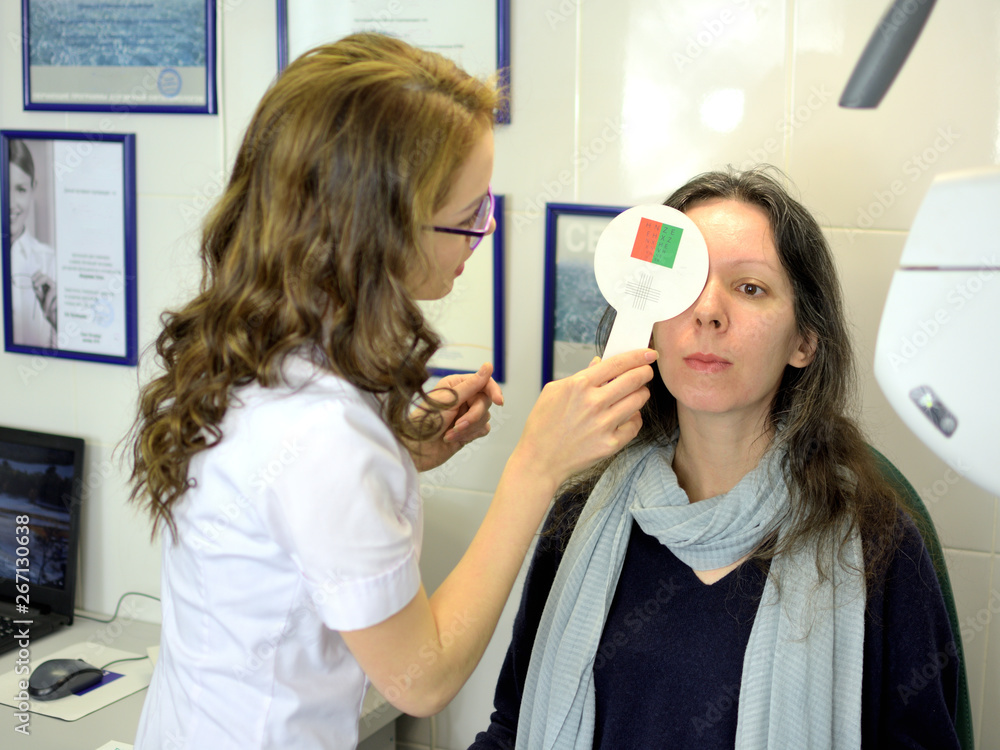 young pretty woman undergone a visual acuity test with ophthalmologist ...