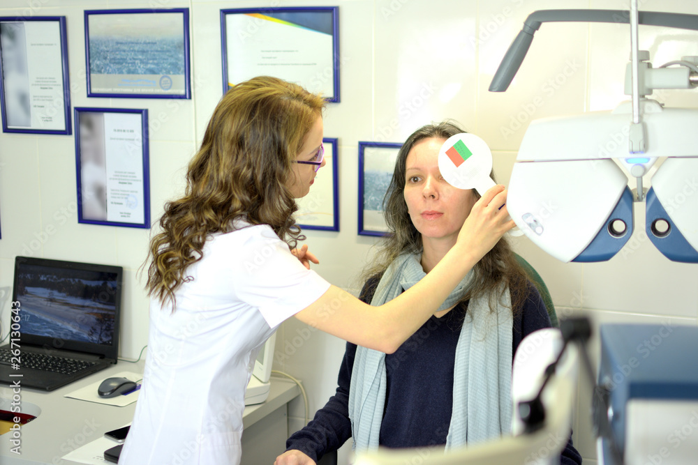 young pretty woman undergone a visual acuity test with ophthalmologist ...
