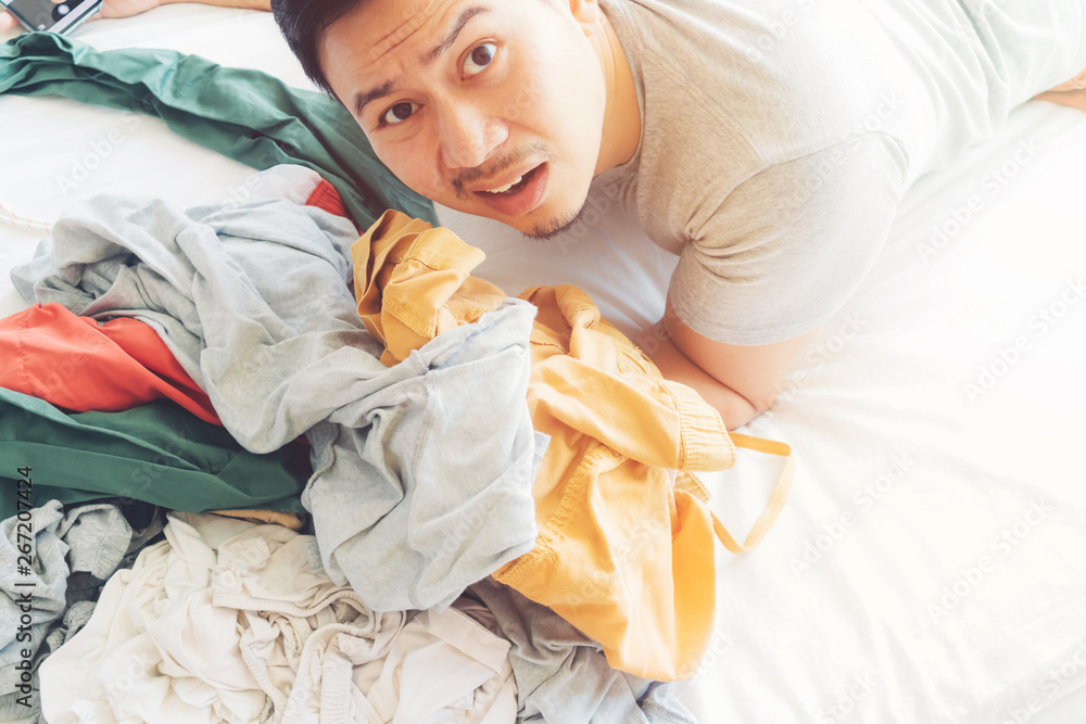 Shocked and sad man who has to take care of all the pile of clothes ...