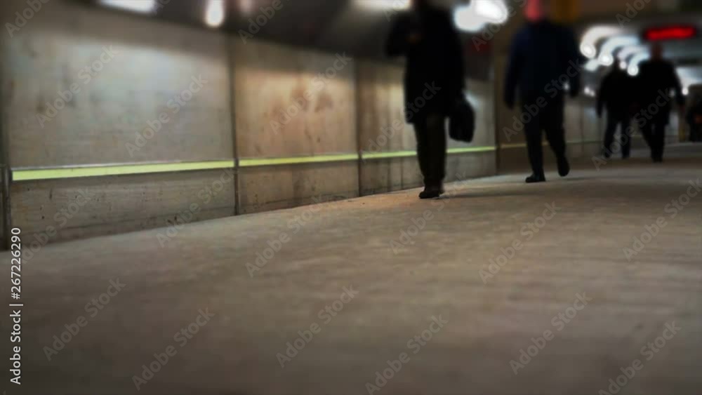 People walk through underground tunnel commuting.Many men and women are ...