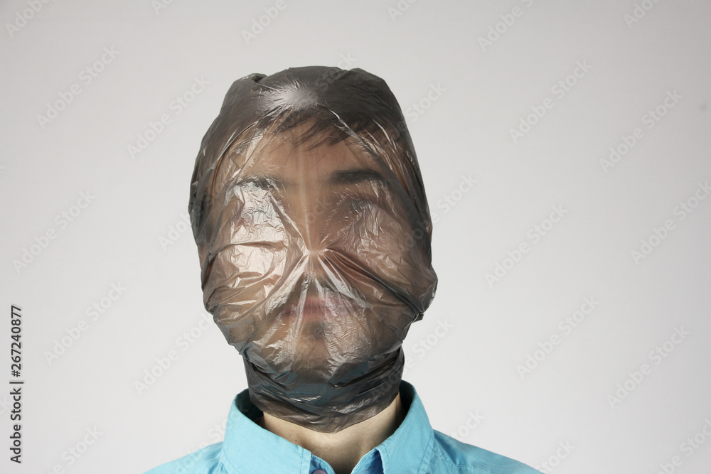 black plastic bag wraps around a human head, gray background, concept ...