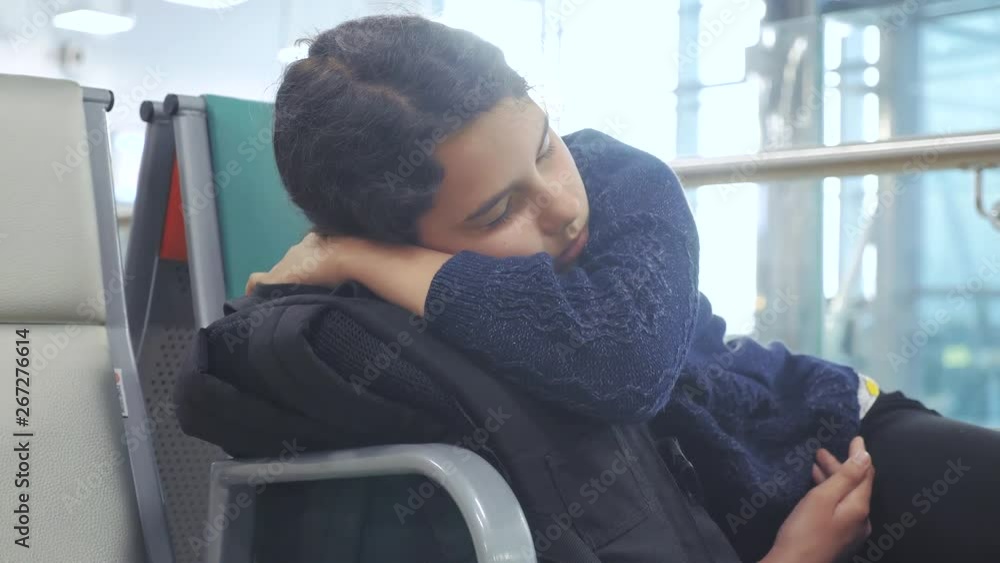 Vidéo Stock Tired girl teen traveler sleeping on the airport waiting ...