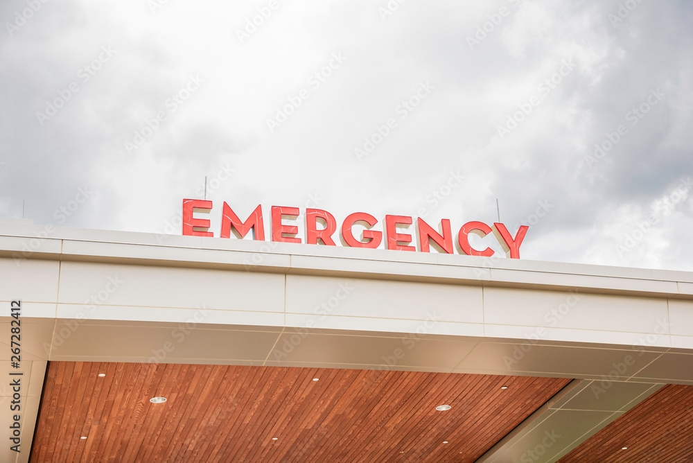 The bold and highly visible red letters of the "emergency" sign by the ...