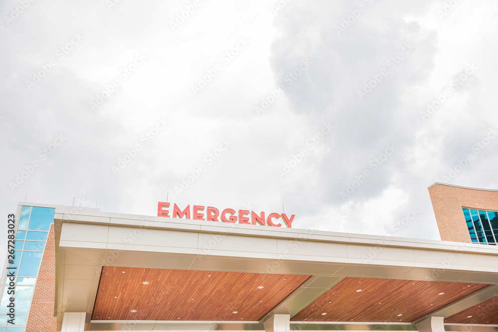 A very prominent all-caps 3D "emergency" sign letters in red on top of ...