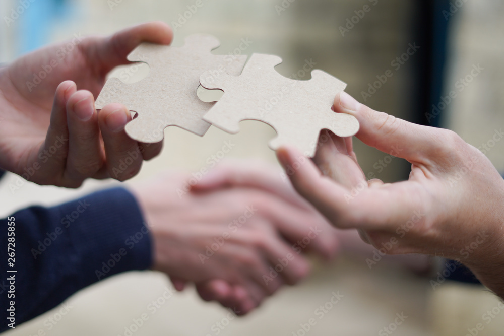 Two men handshake trying to connect couple puzzle piece.Symbol of ...