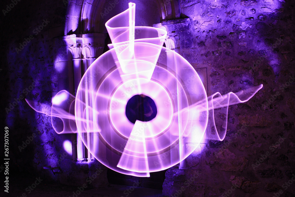 Circle and ripple in lightpainting with neon pink in front of a wooden ...