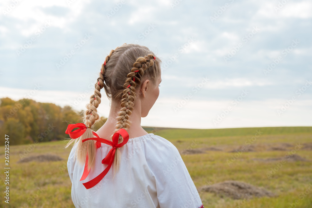 Russian girl Slavic appearance with braids with red ribbons in the ...