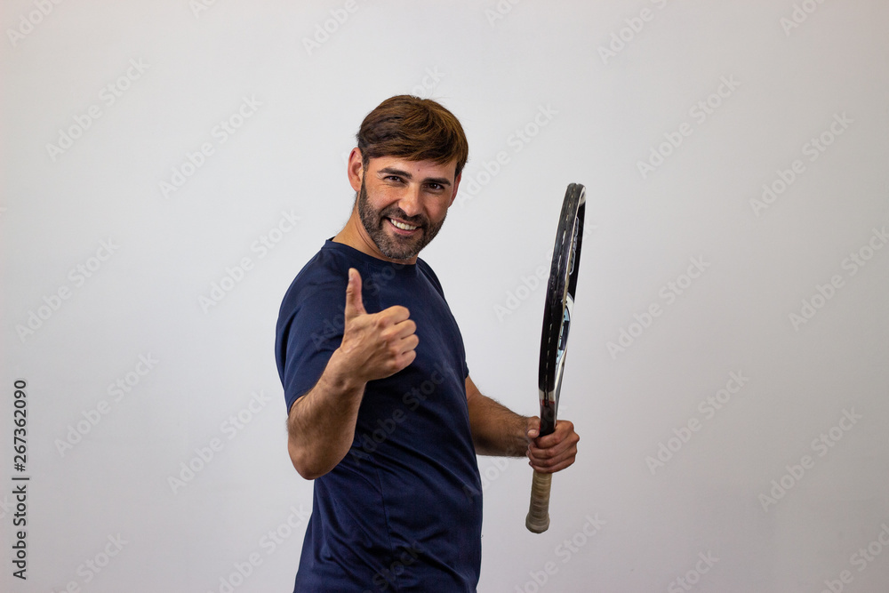 Portrait of handsome young man playing tennis holding a racket with ...