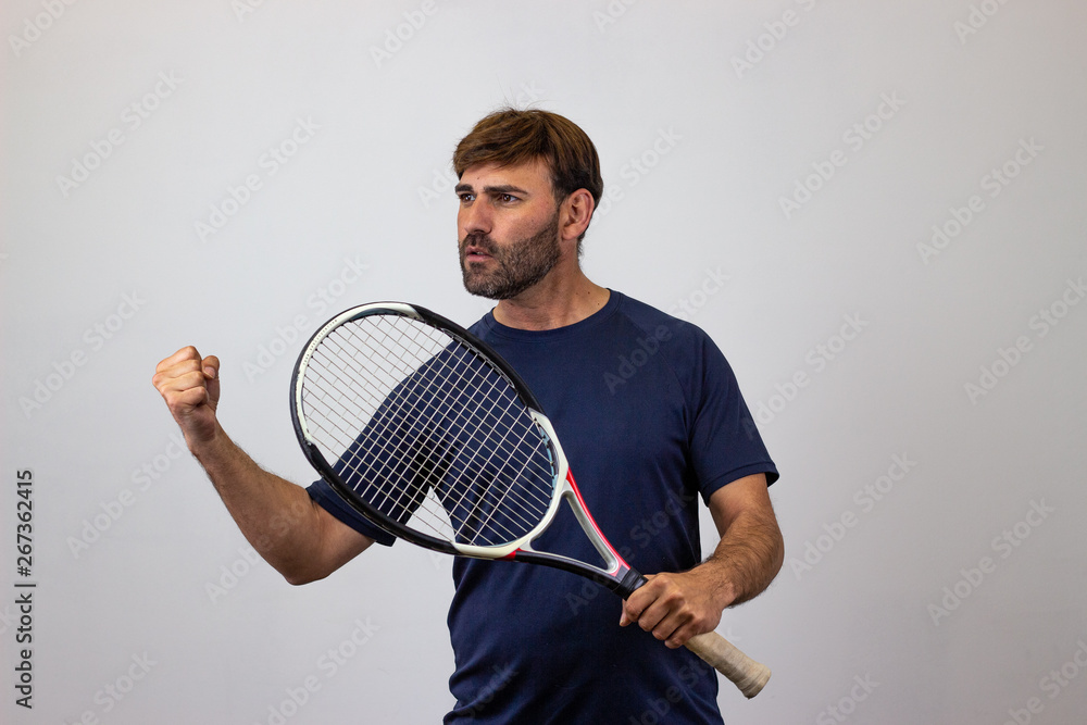 Portrait of handsome young man playing tennis holding a racket with ...