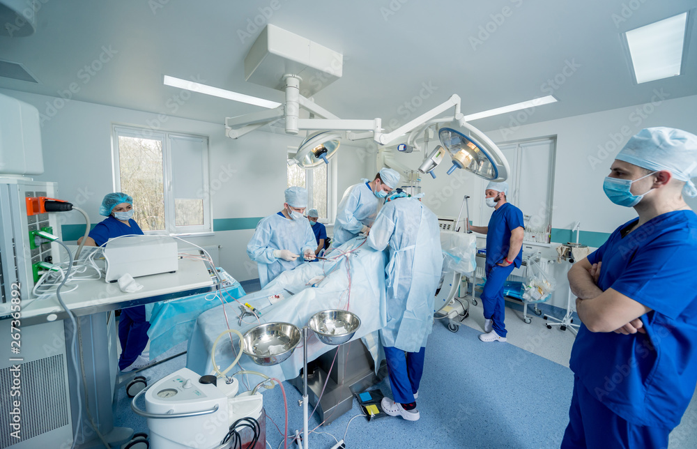 Spinal surgery. Group of surgeons in operating room with surgery ...