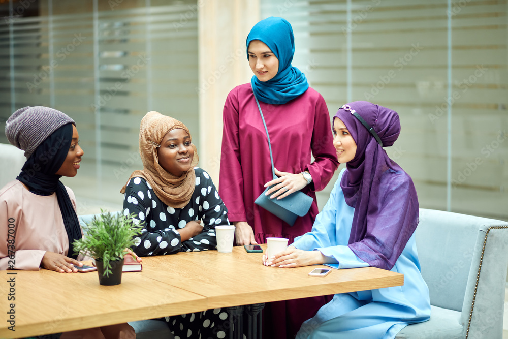 Muslim young women of diverse ethnicity, dressed in colourful national ...