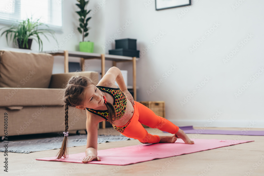 Little girl doing plank exercise at home. Stock Photo | Adobe Stock