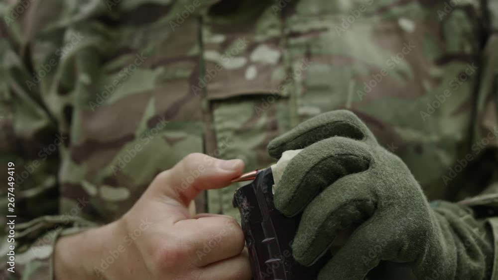 Soldier with assault rifle in hand. Loading kalashnikov magazine ...