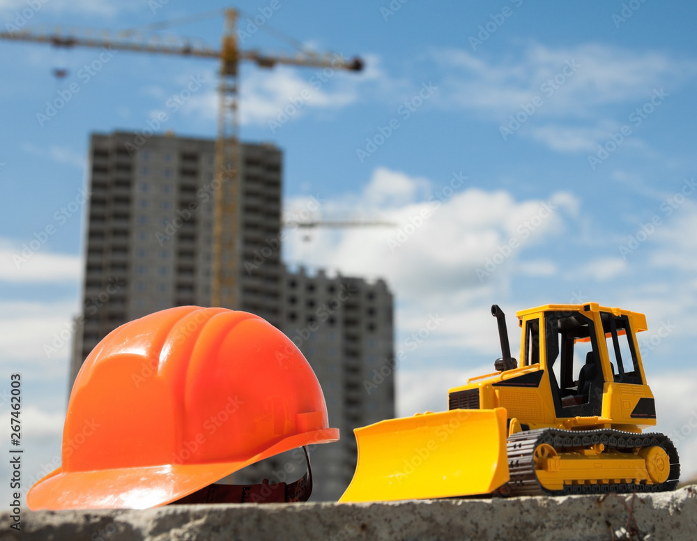 Builder's helmet and toy bulldozer in the construction site Stock Photo ...