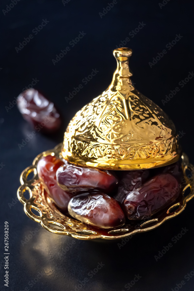 Organic dried dates in traditional arabic golden plate. Holy month ...