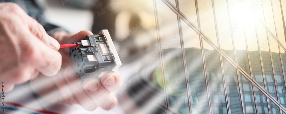 Electrician connecting a wire into a power socket, light effect ...