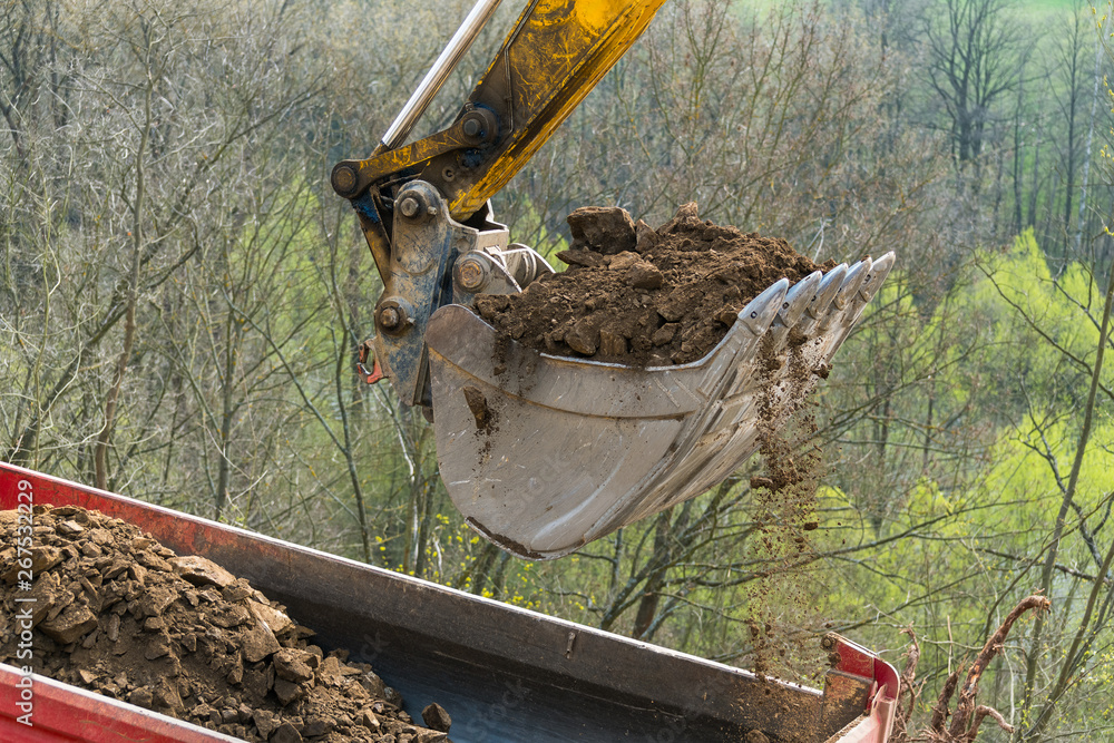 Working excavator shovel. Dump truck detail with soil pile. Building ...
