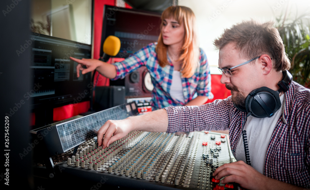 Music producer and musician in recording studio using soundboard for ...