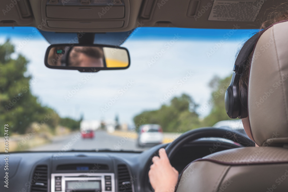 The girl is driving on the highway in Australia. View from the back ...