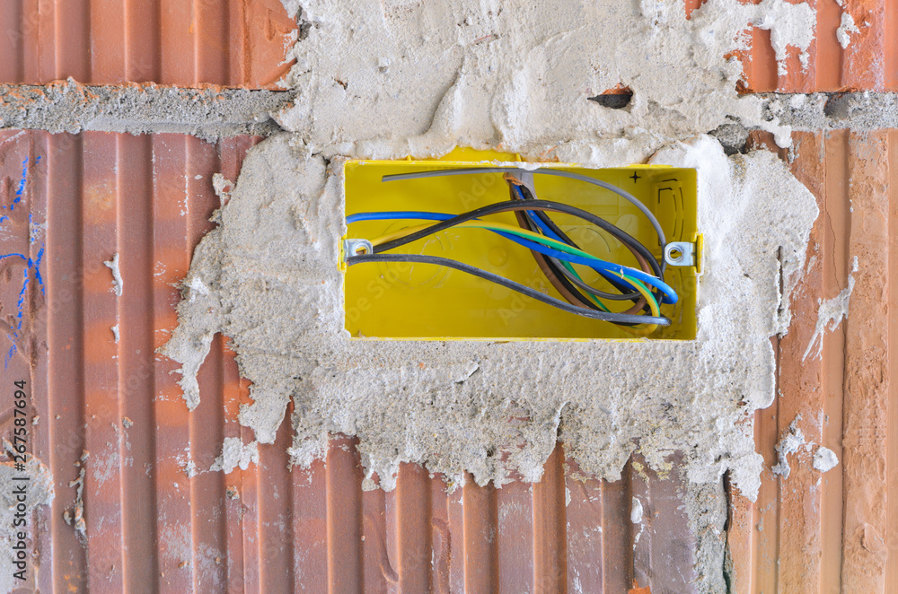 Electricity wire instalation in brick wall, construction site interior ...