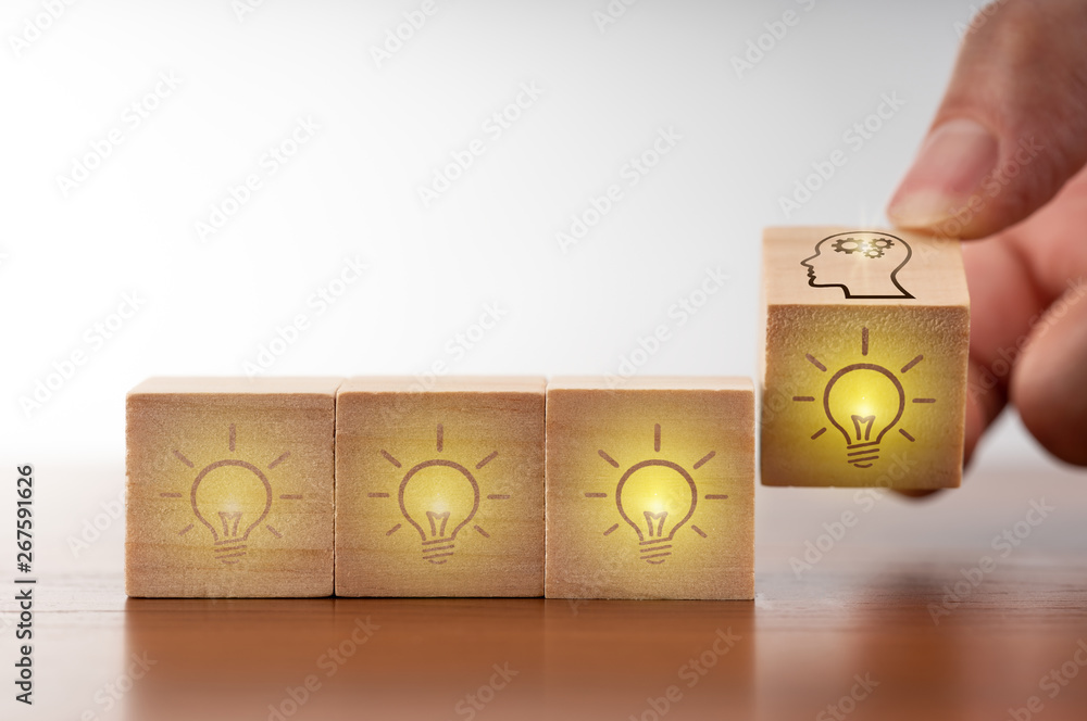 Hand flip over wooden cube block with head human symbol and light bulb. Concept creative idea ...