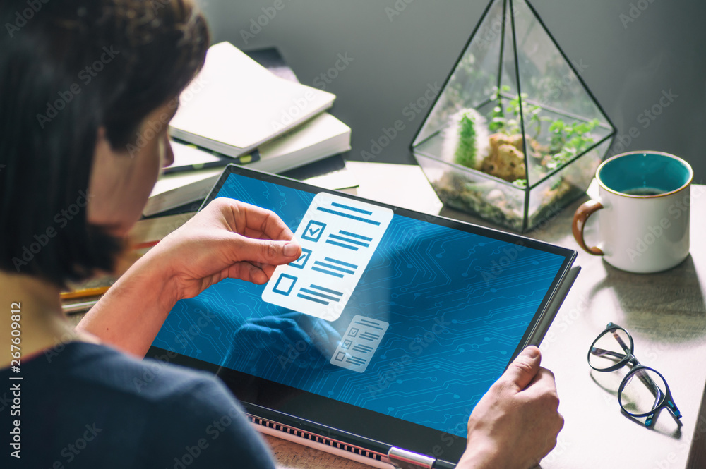 Woman with laptop on her desk. She holds a questionnaire icon. Concept ...
