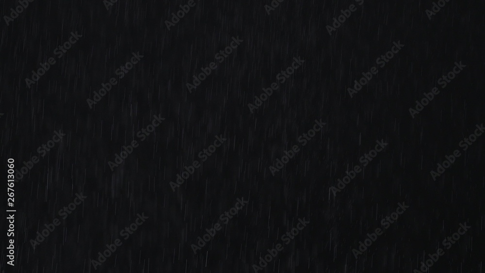 4k Heavy angled rain falling in front of the camera against black ...