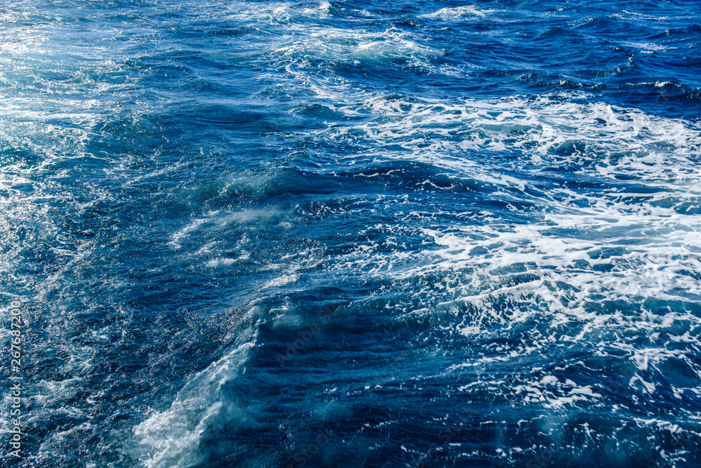 Wave trace with white foam on a water surface behind of fast moving ...