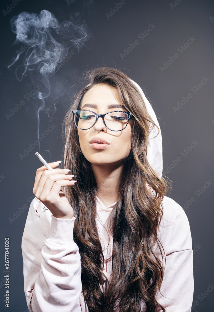 Cancer cures smoking. Pretty woman with long hair smoking cigarette ...