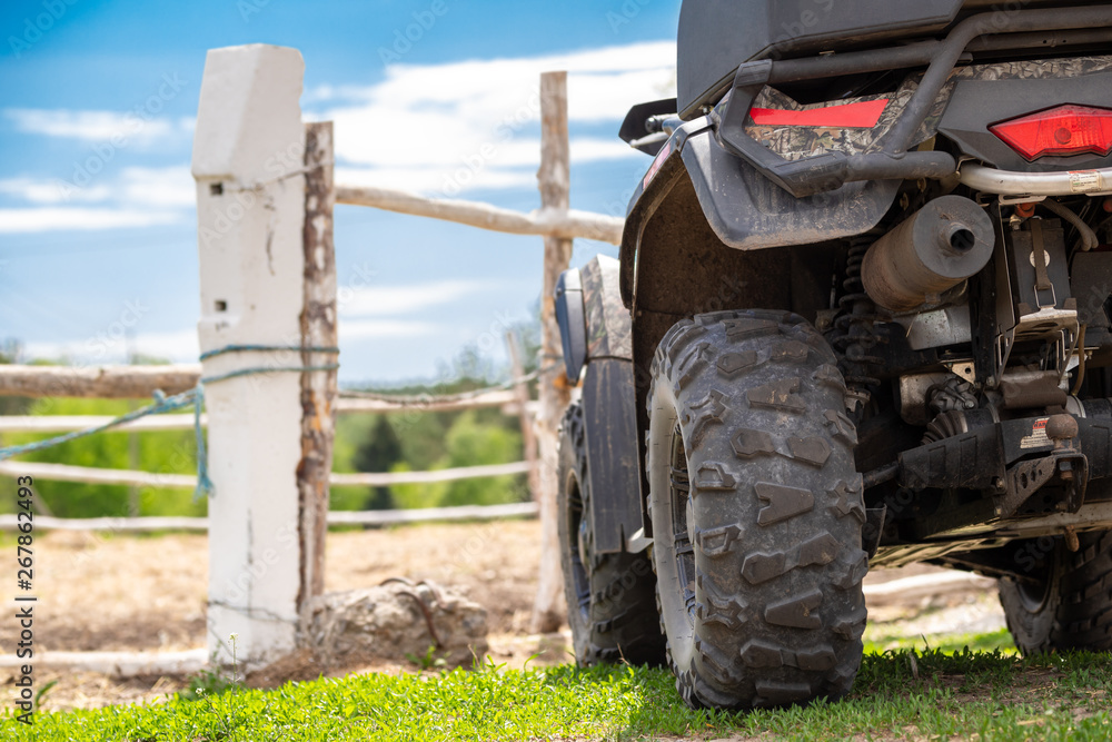 ATV quad bike vehicle standing near wooden fence at farm or horse ...