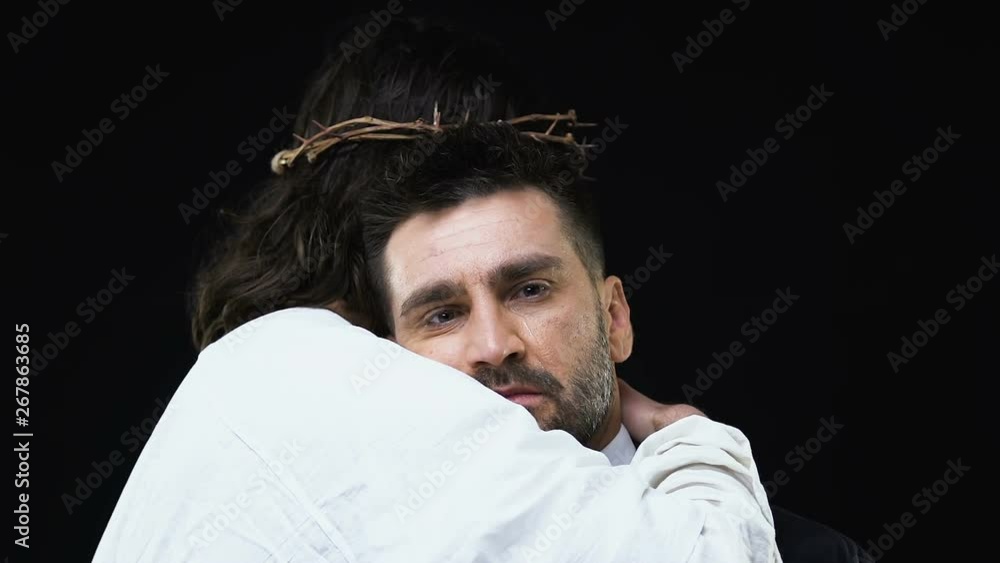 Vidéo Stock Jesus Christ hugging crying business man against dark ...