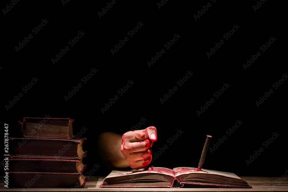 bloody hand stab an old book with pin or nail, horror concept Stock ...