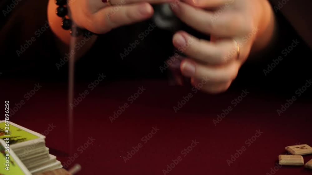A witch is fortune teller in robe performs a rite of black magic ...