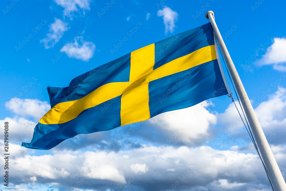 Swedish flag against blue sky with white clouds. Beautiful swedish flag ...