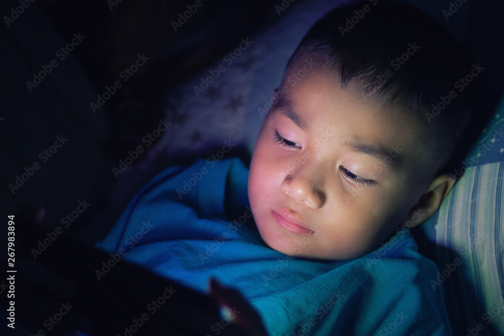 Asian child using smartphone at night on the bed in dark room, Using ...