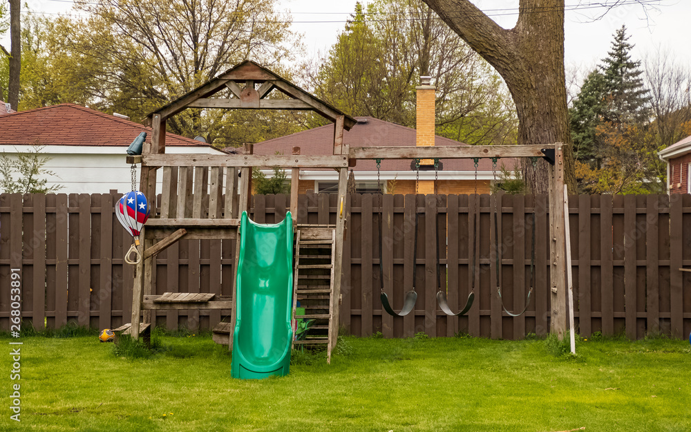 Swing set in backyard during spring season Stock Photo | Adobe Stock