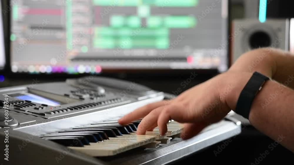 Shot of a musician's hands playing chords on a keyboard in a home ...