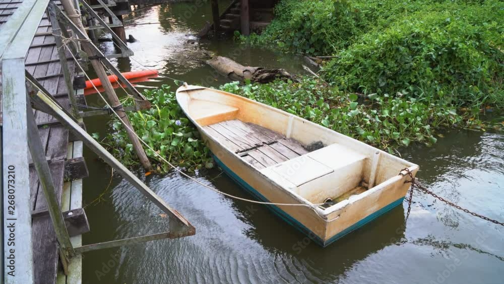 Vidéo Stock Top view of a wooden boat tied to a jetty floating with the ...
